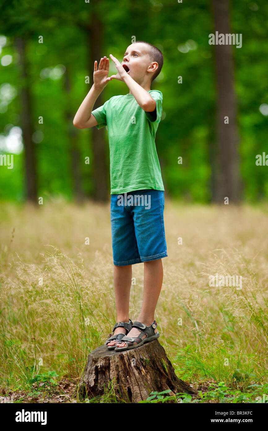 Cute little kid trying to make echo in the forest by shouting Stock ...
