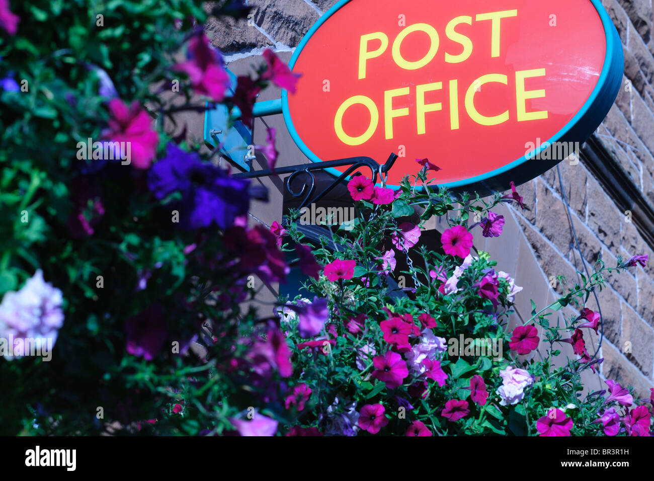 Post office sign with flower baskets in British village Stock Photo - Alamy