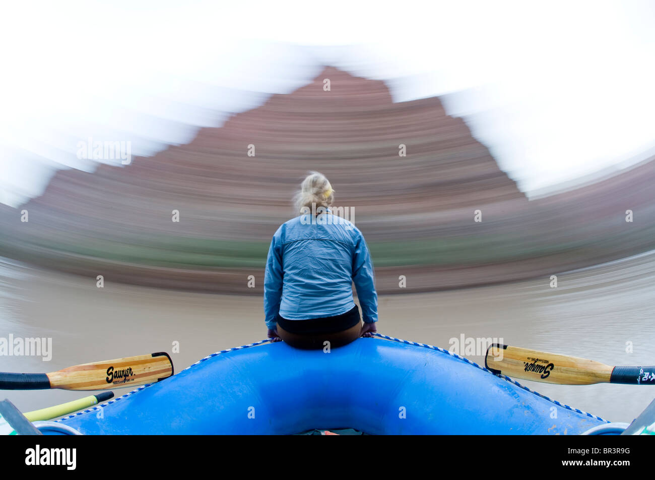Woman sitting on the front of a raft while it spins blurring the ...