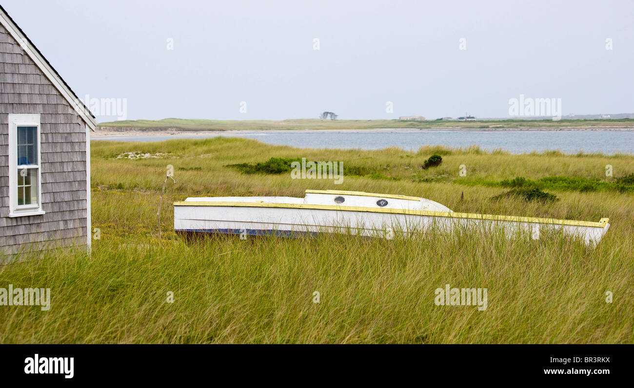 An old wooden sailboat without its mast rests in the grass Stock Photo ...