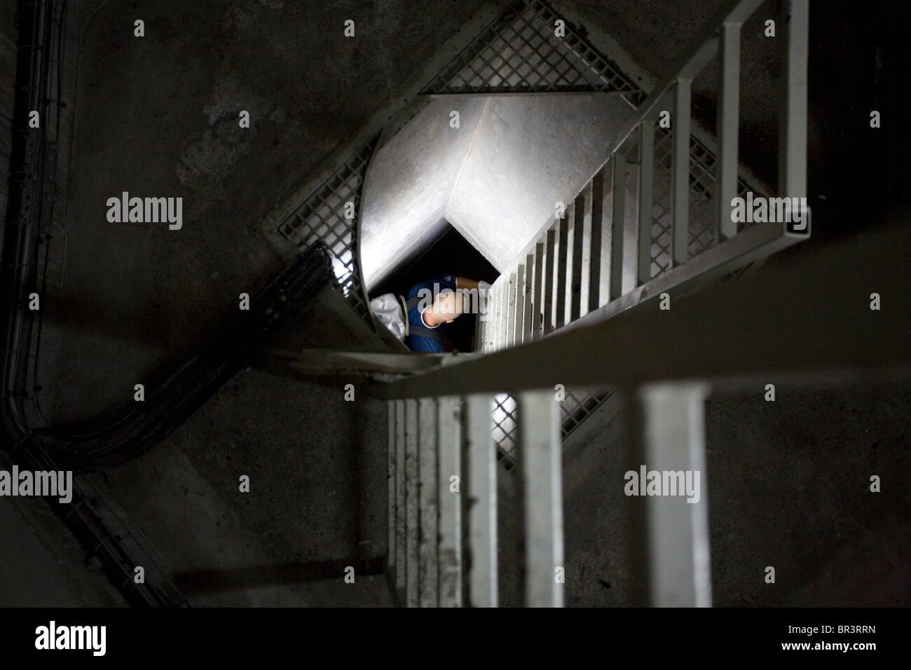 A man climbing down a ladder in one of the pillars while working on the ...