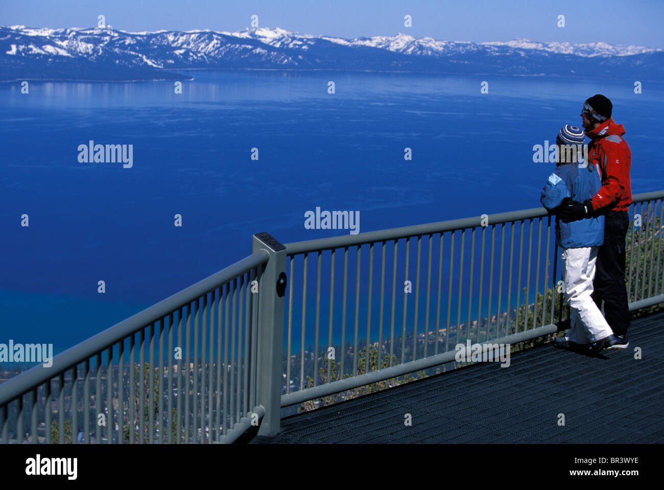 Man and woman taking in the view of a blue lake from a lookout Stock ...