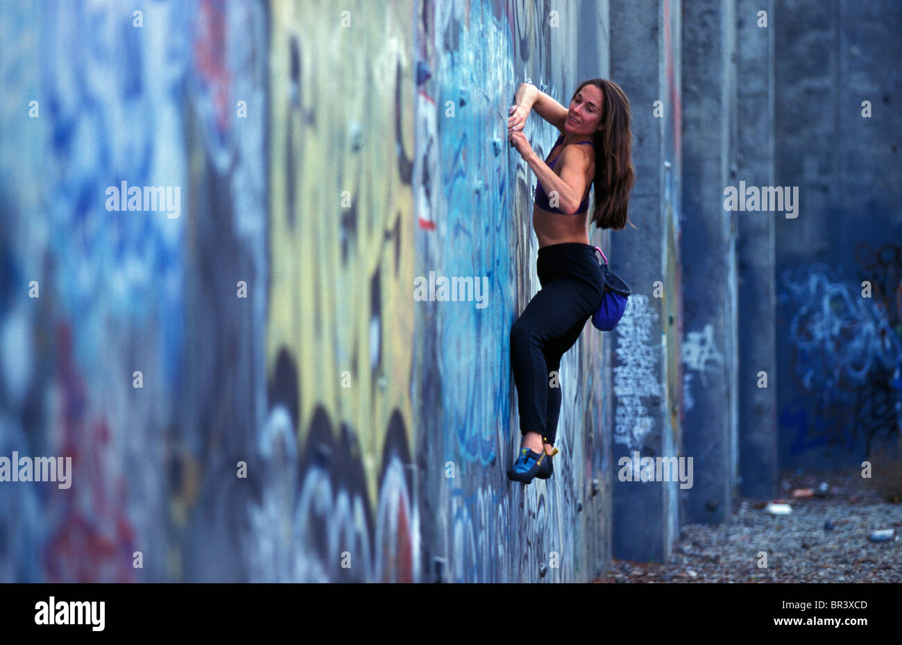 Attractive woman buildering on a wall covered with graffiti Stock Photo ...