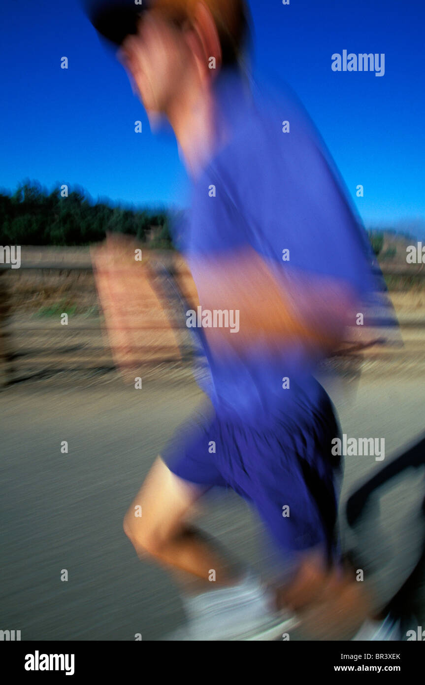 Man running next to a fence (motion blur Stock Photo - Alamy