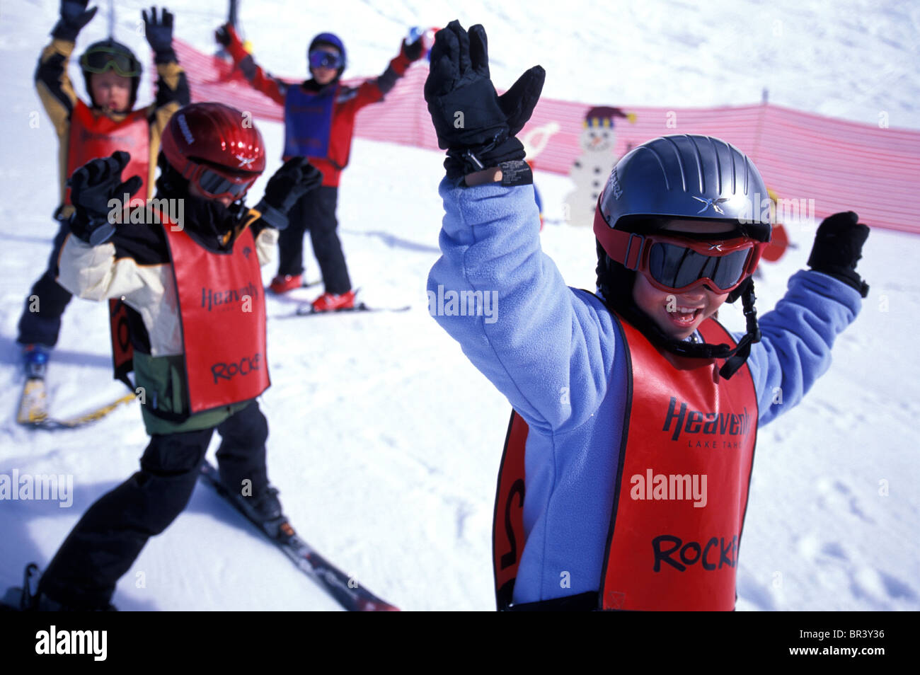 Ski school kids snow plowing with their hands up Stock Photo - Alamy