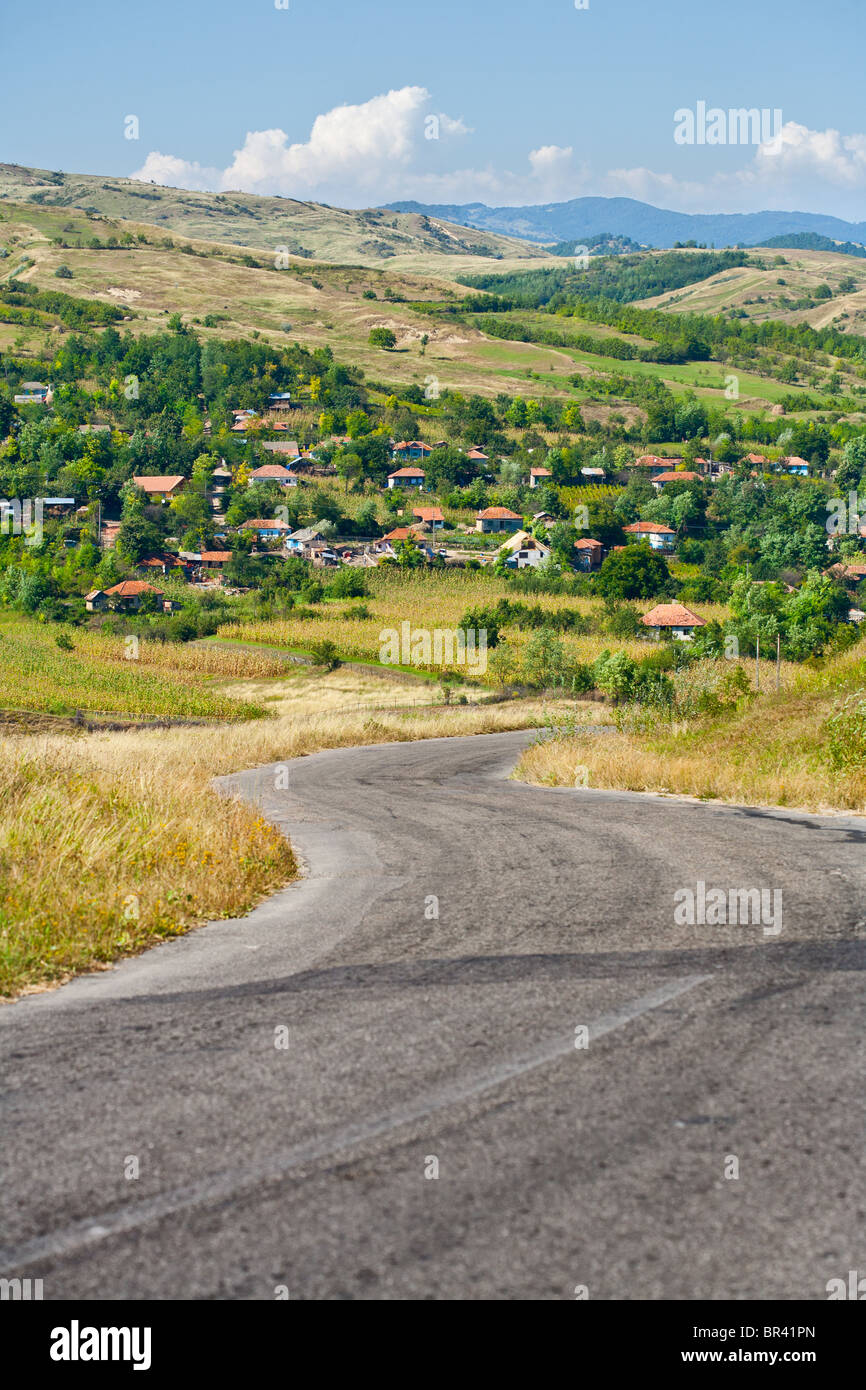 Alpine landscape with a road going to a village Stock Photo - Alamy