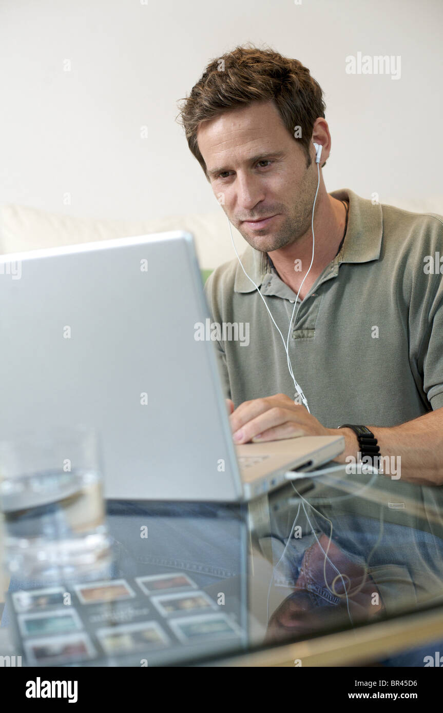 Man earbuds using laptop Stock Photo - Alamy