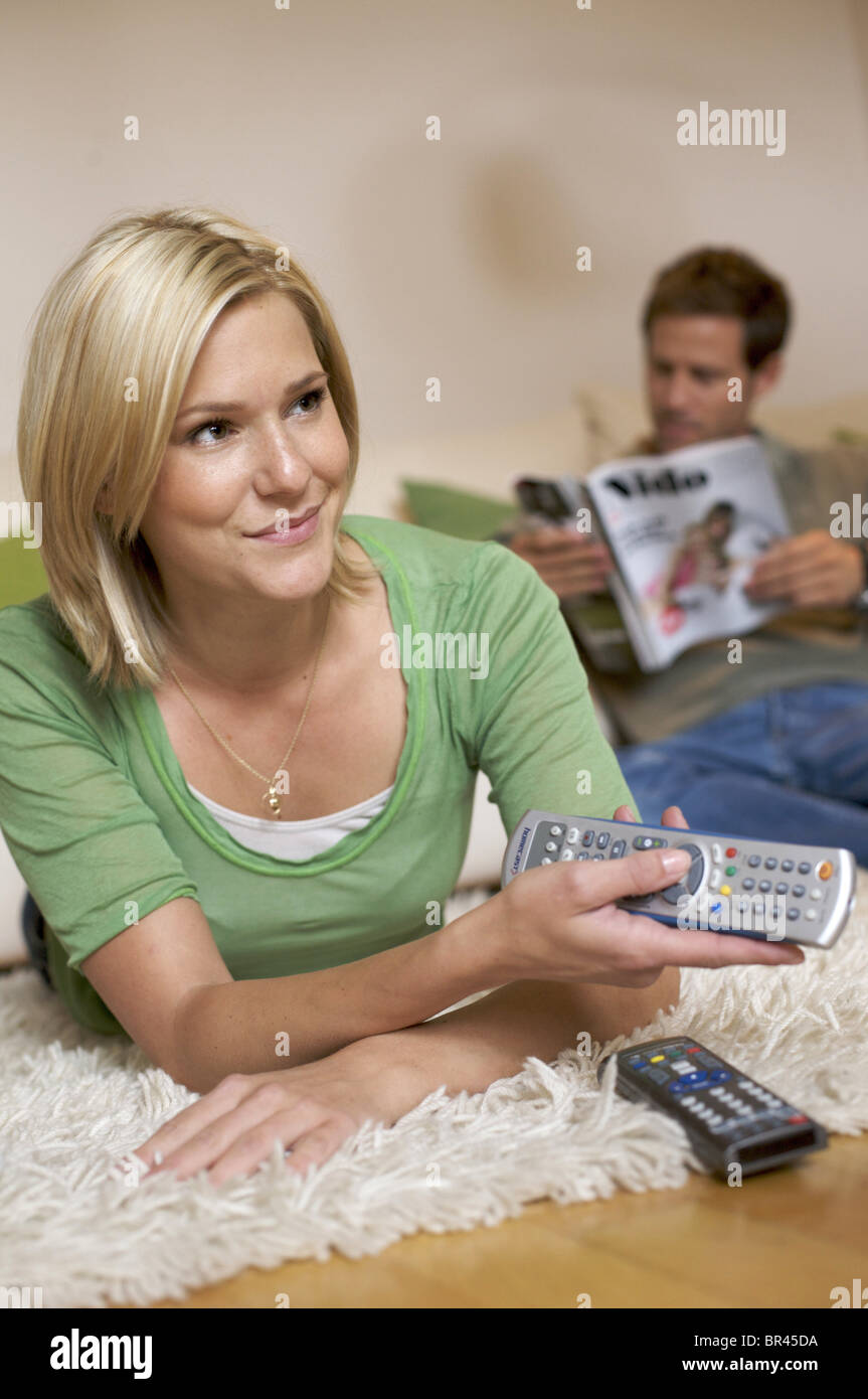 Couple at home with remote control and magazine Stock Photo - Alamy