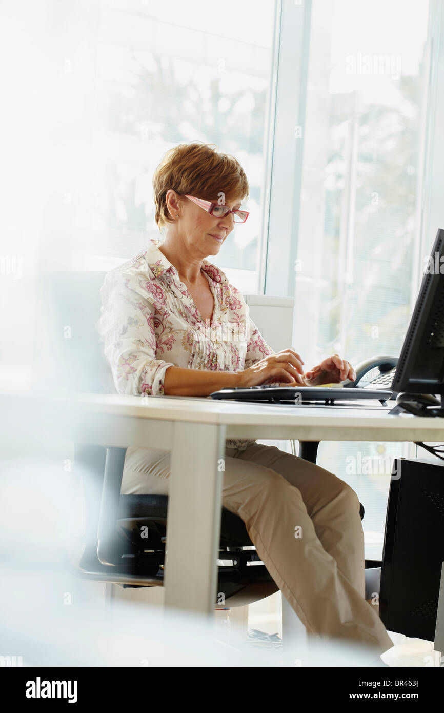 Middle-aged woman working at computer Stock Photo - Alamy