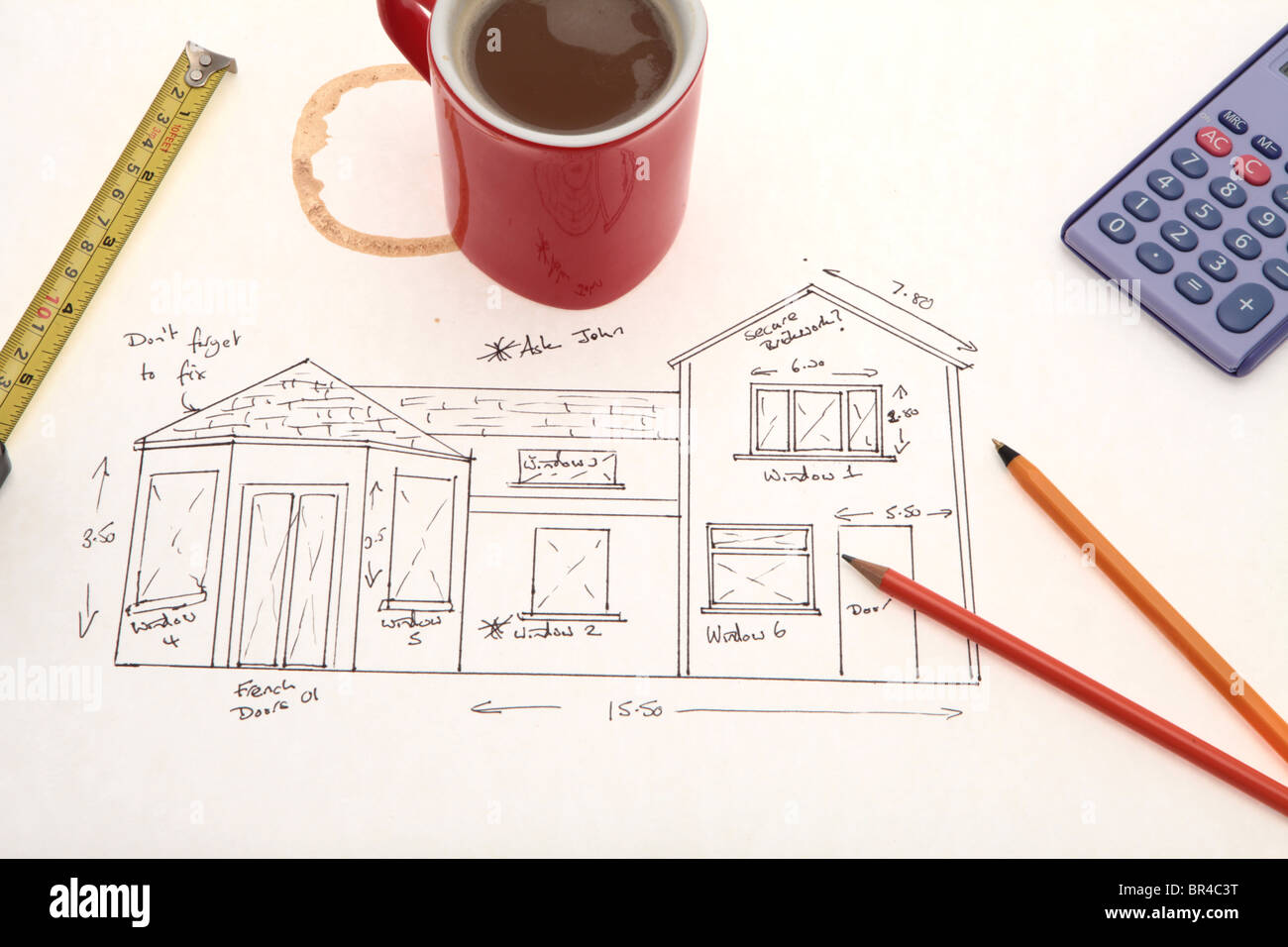 A builders rough sketch blueprint, a mug of coffee with calculator and ...