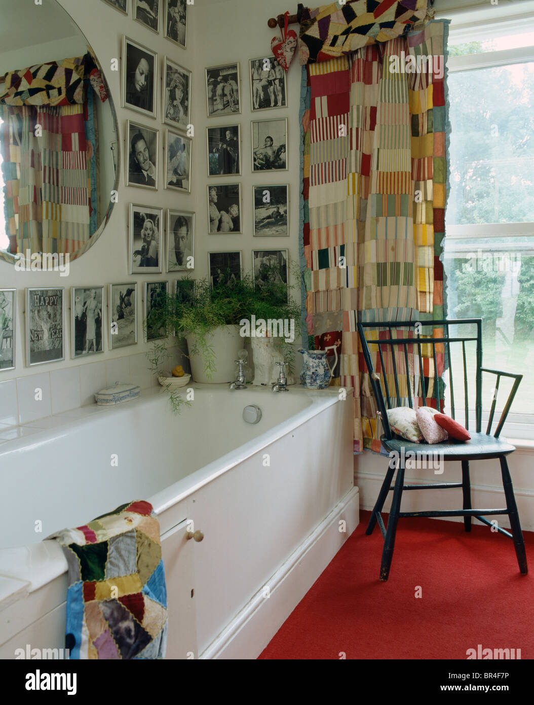 Black+white photograph collection above bath in bathroom with patchwork ...