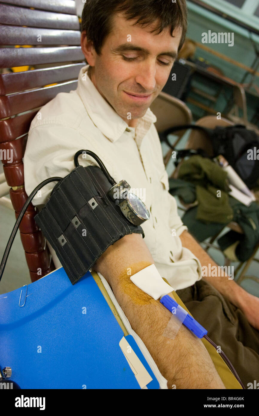 Man gives blood donation with needle in his arm Stock Photo - Alamy