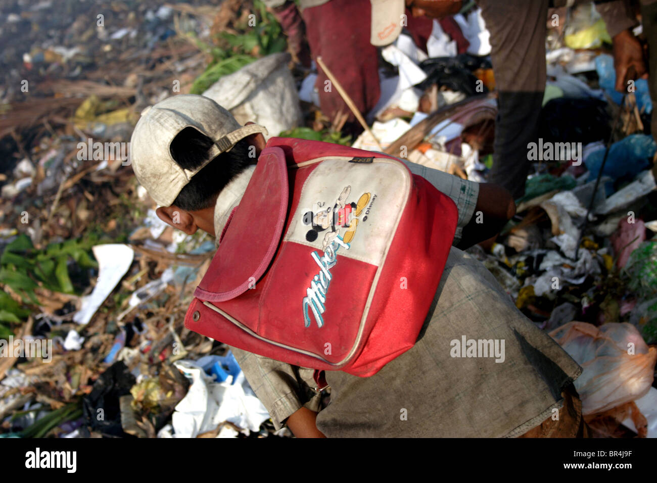 A young child laborer boy is wearing a Mickey Mouse backpack at The ...