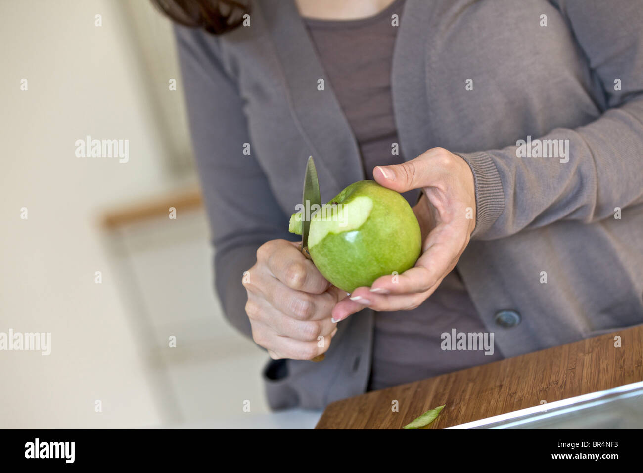 Woman peeling apple in kitchen, close-up Stock Photo - Alamy
