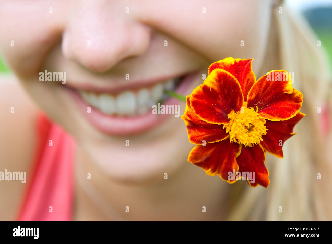 flower in the mouth of a young girl Stock Photo - Alamy