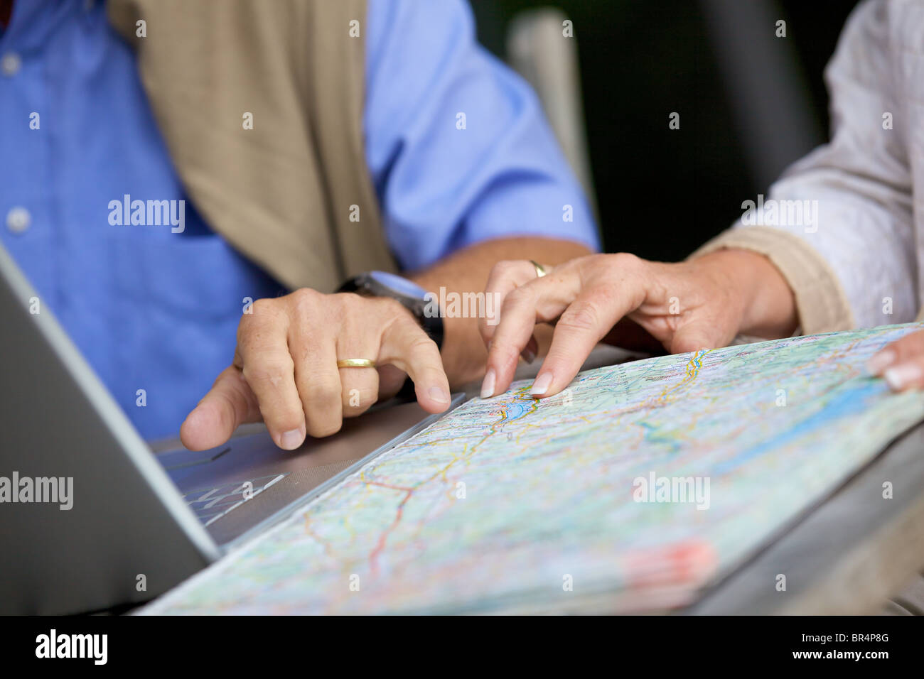 Senior couple laptop and road map, close-up Stock Photo - Alamy