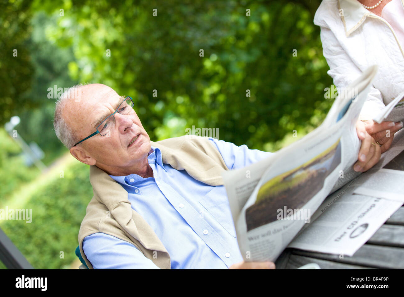 Senior couple reading newspaper on the terrace Stock Photo - Alamy