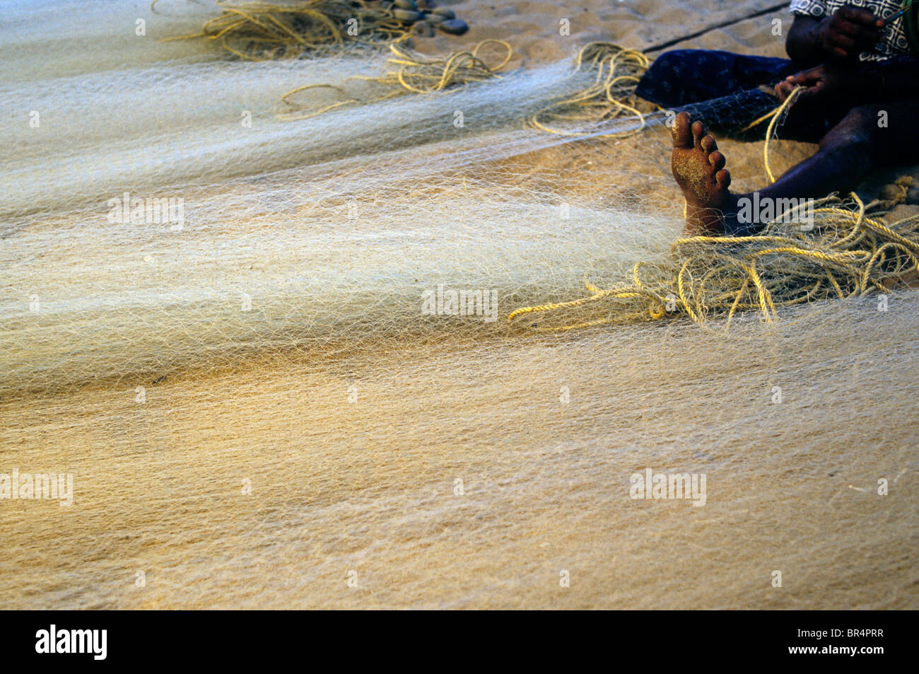 A fisherman repairing fishing-net in Puri, Orissa, India Stock Photo ...