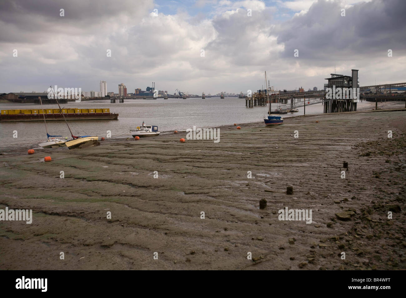 River Thames at low tide with the city of London and the Thames Barrier ...