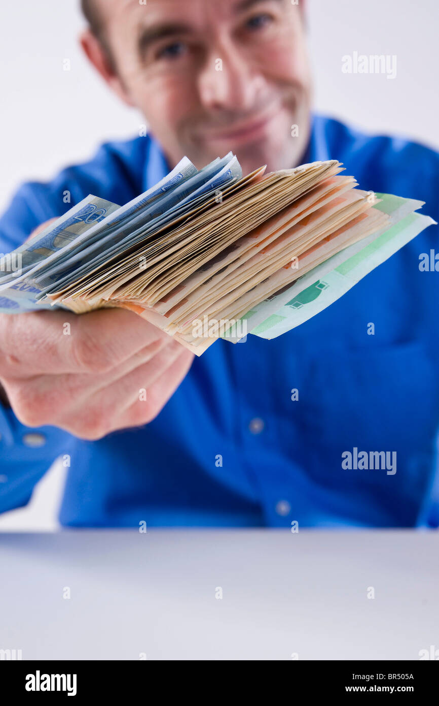 Man holding a pack of bank notes Stock Photo - Alamy