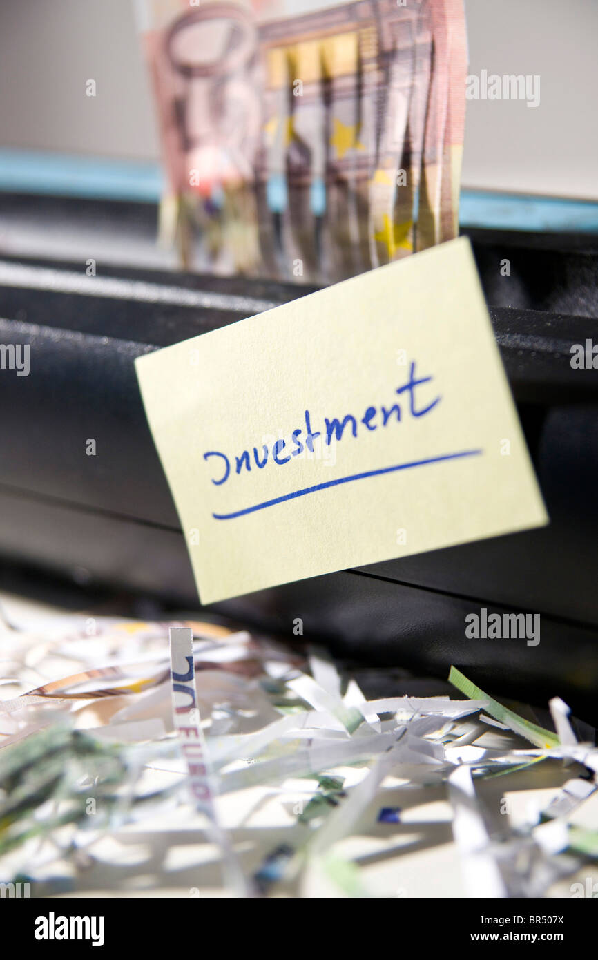 Bank notes in a shredder, "Investment" on a piece of paper Stock Photo ...