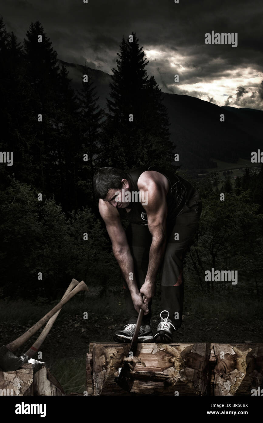 A man chops a tree trunk with and axe during traditional rural sport ...