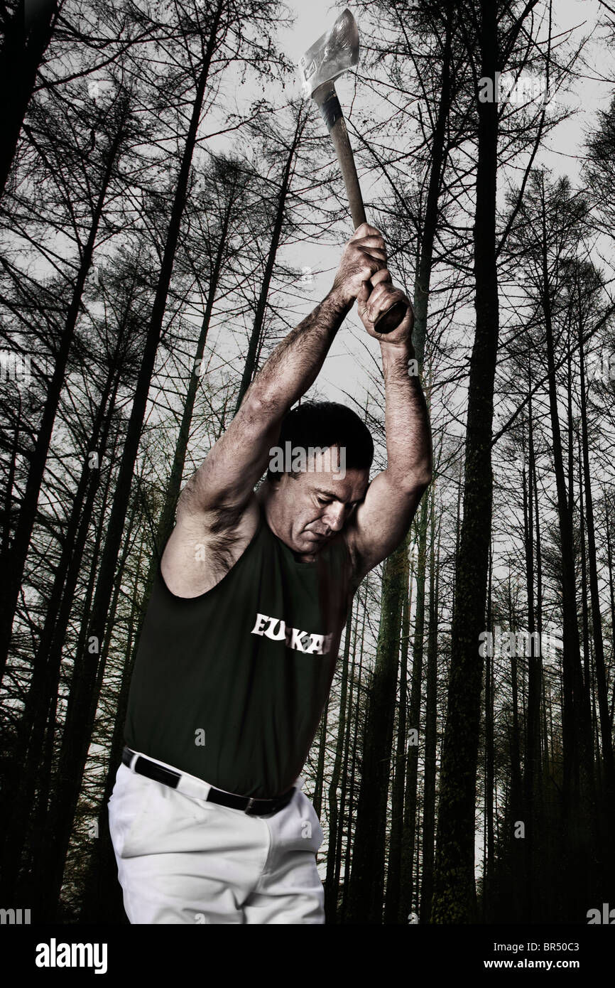 A man chops a tree with an axe during traditional rural sport training ...