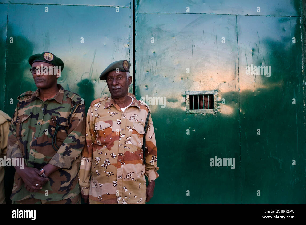 Mandera prison guards stand by a gate while a prisoner looks though the ...