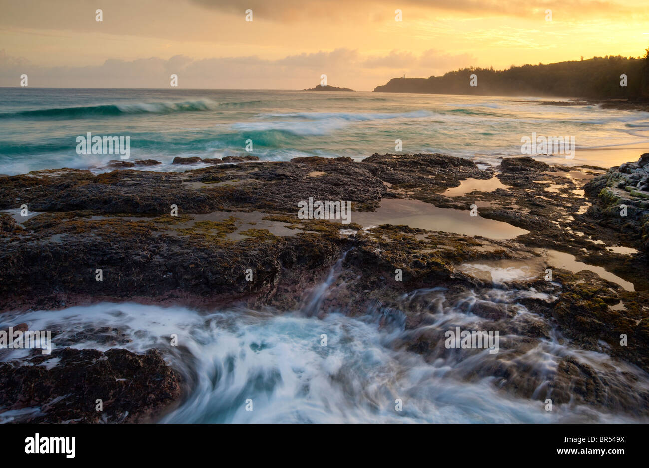 Kauai, HI Dawn light on Secret beach and surf on rock pools Stock Photo ...