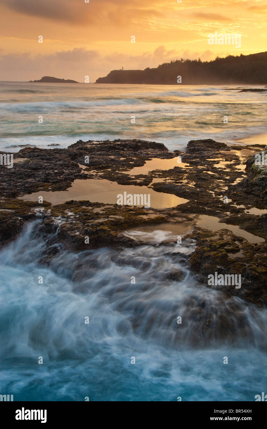 Kauai, HI Dawn light on Secret beach and surf on rock pools Stock Photo ...