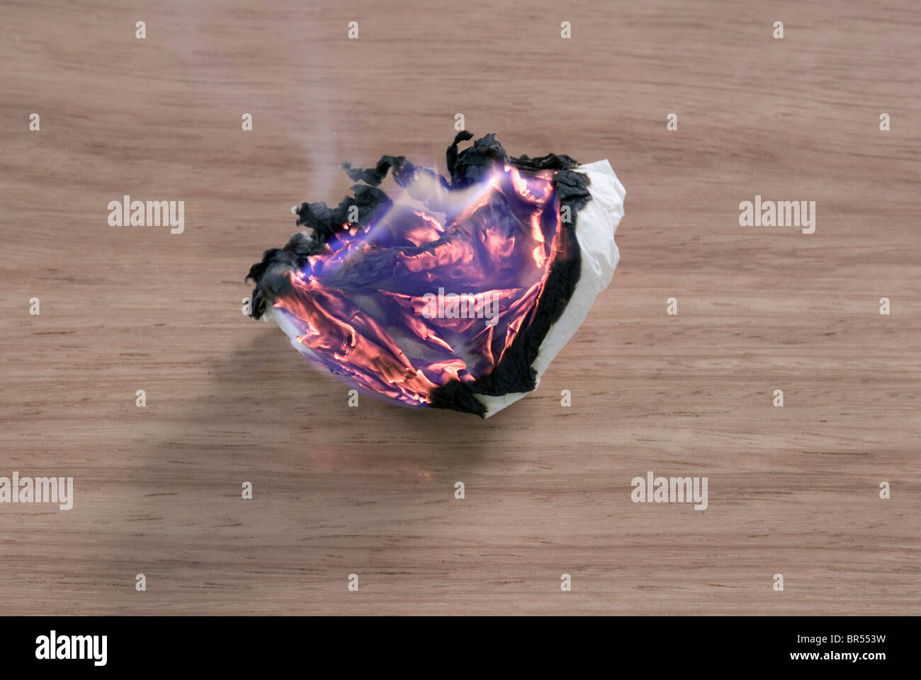 burning crumpled paper on wooden floor Stock Photo - Alamy