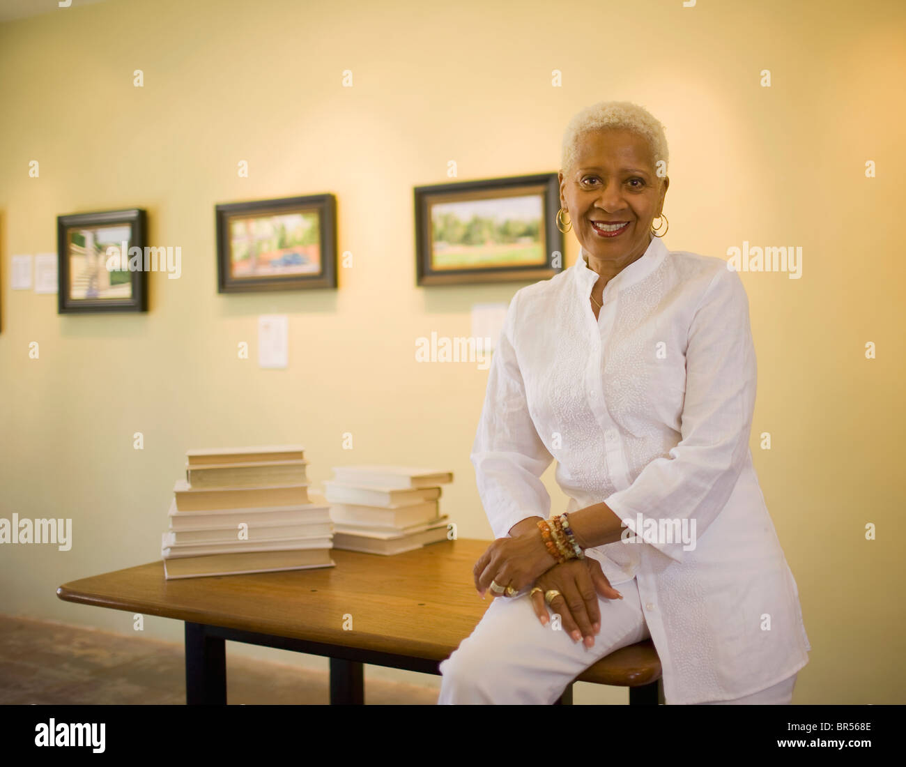 Black woman sitting on table Stock Photo - Alamy