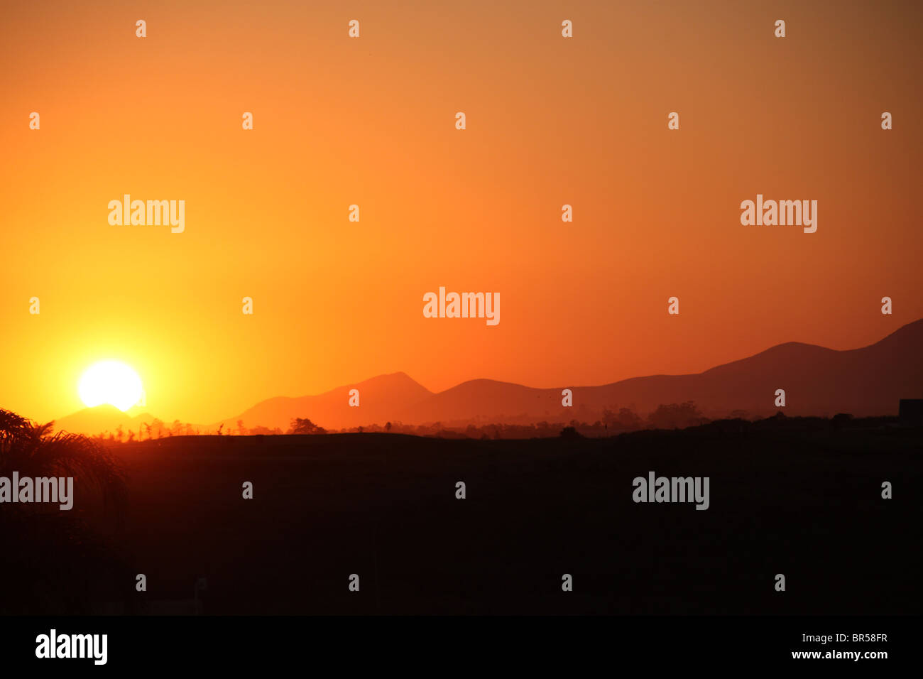 African Sunset with mountains as backdrop Stock Photo - Alamy