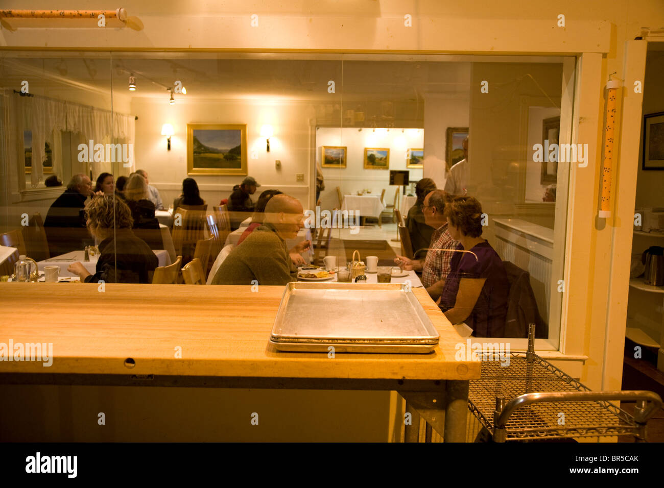 Restaurant patrons dine while bakers work in the kitchen Stock Photo ...