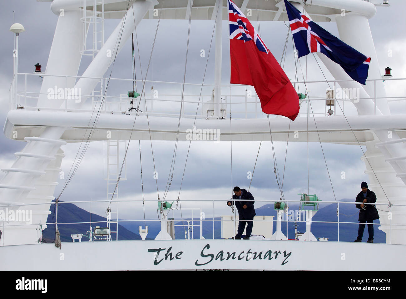 Ship workers hoisting the Icelandic flag as the cruise ship approaches ...