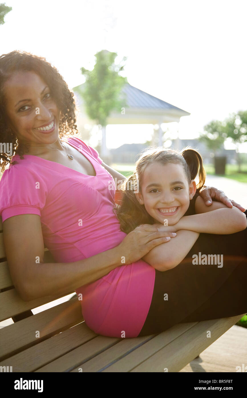 Mother and daughter sitting on park bench Stock Photo - Alamy