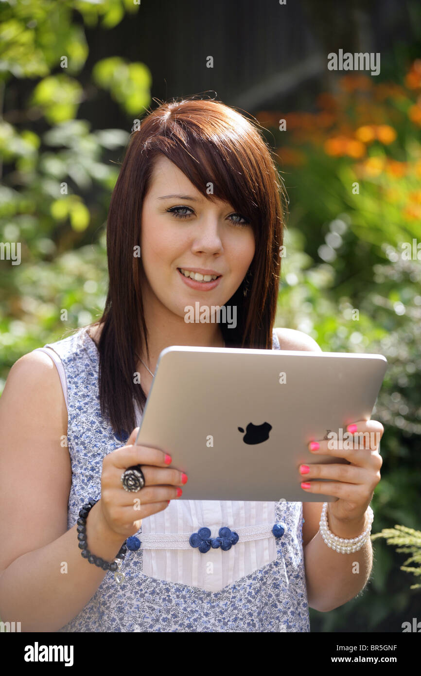 Woman standing outside holding an Apple iPad Stock Photo - Alamy