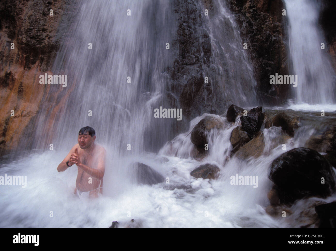 Bathing beneath a waterfall Stock Photo - Alamy