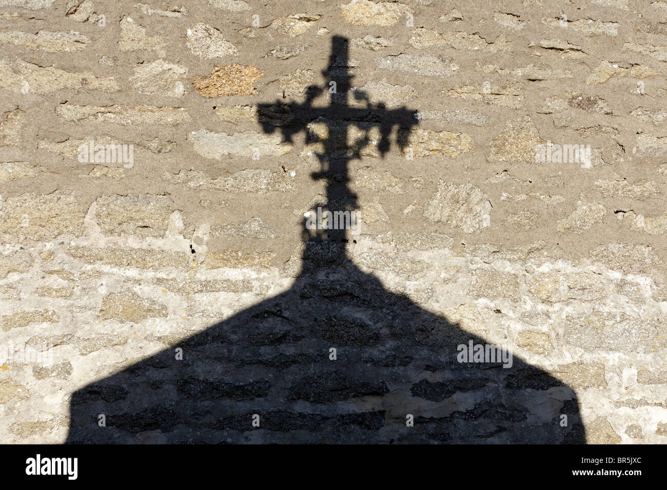 shadow of christian religious cross on stone wall, brittany, france ...