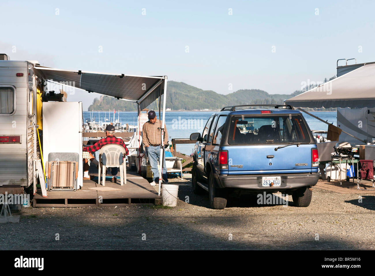 fishermen relax in late afternoon on makeshift patio outside their RV ...