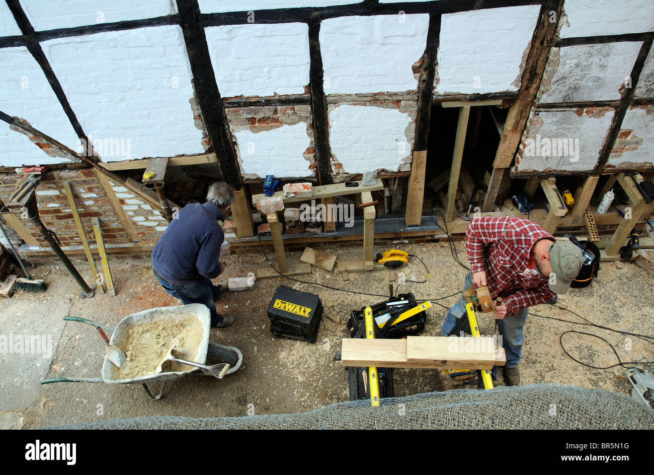 Renovating an old timber framed historic building. Bricklayer forming a ...