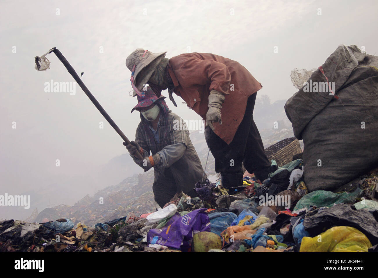 Workers use hooks and gaffs to collect garbage at The Stung Meanchey ...