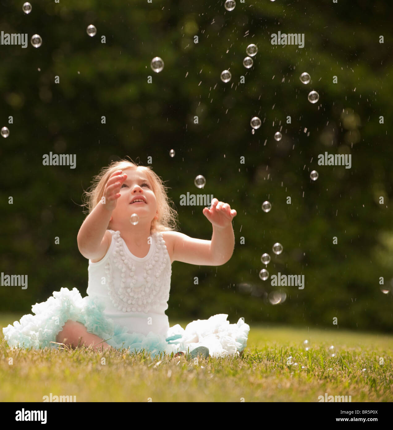 Caucasian girl watching floating bubbles Stock Photo - Alamy