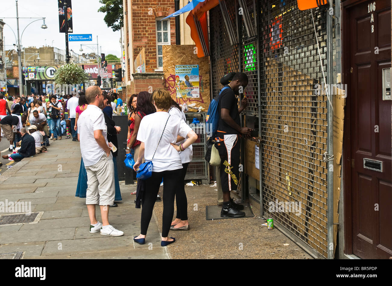 Revellers standing outside a locked up shop at the 2009 Notting ...
