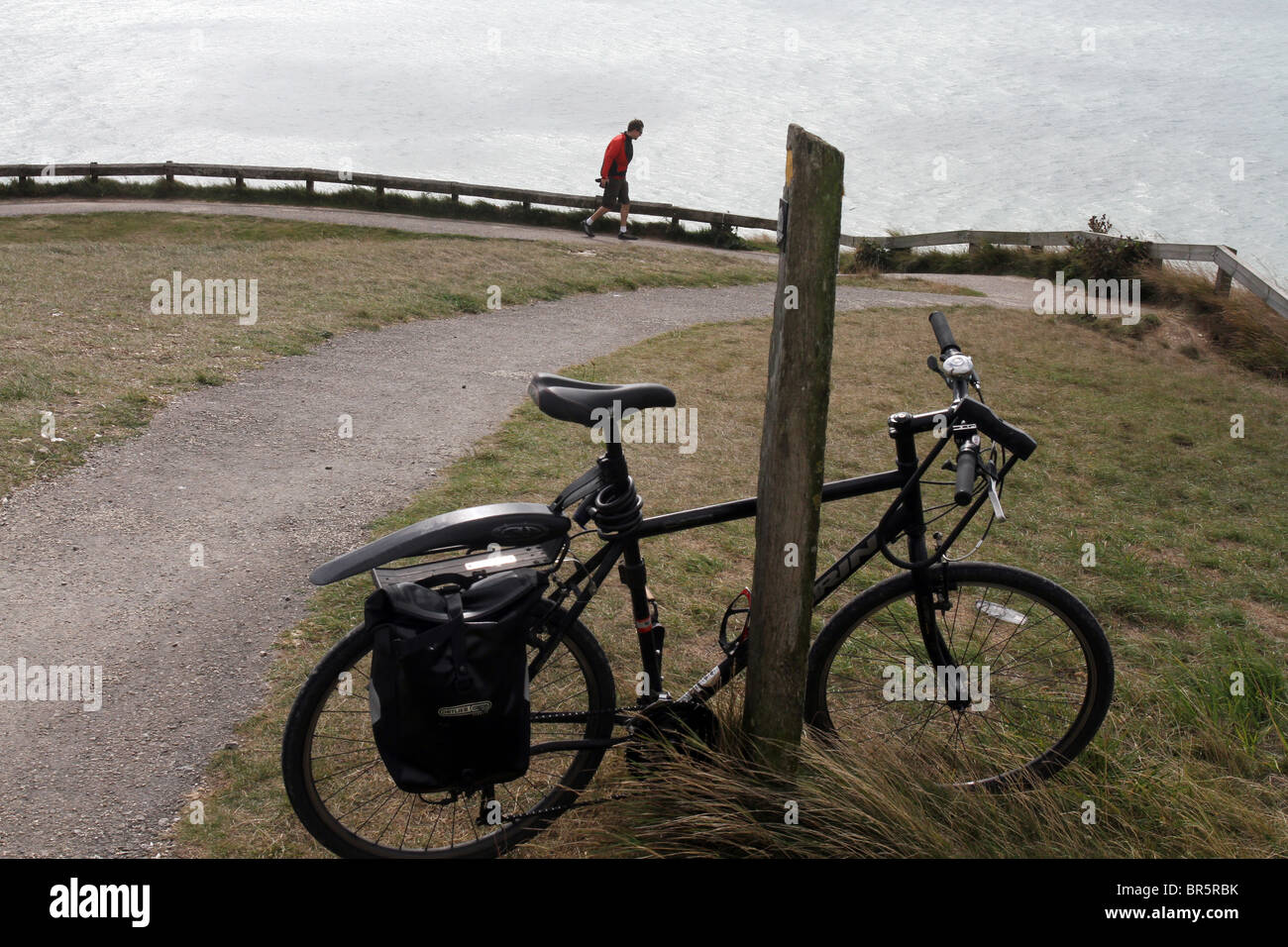 A bicycle on top of a cliff overlooking the sea, with the rider in the ...