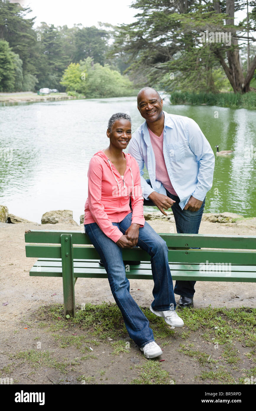 African American couple sitting on bench near lake Stock Photo - Alamy