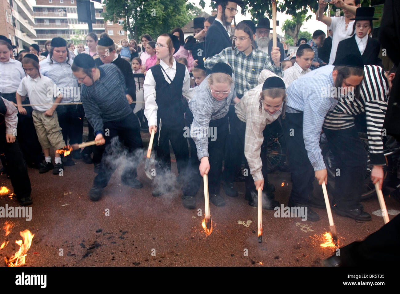 Young orthodox Jewish boys extinguishing their flame torches after a ...