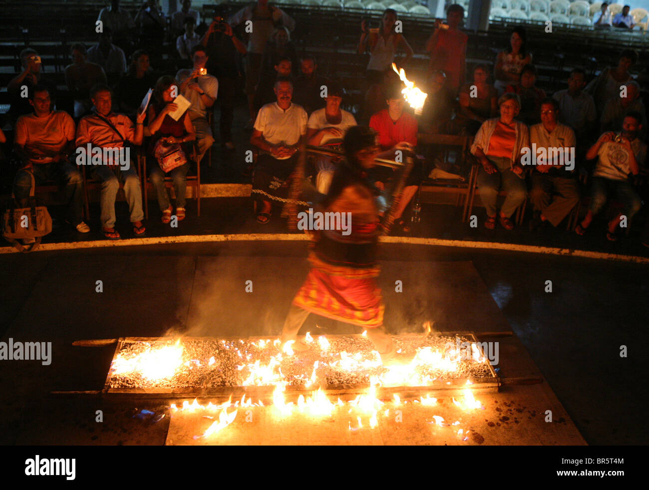 A firewalker stands barefoot over a bed of hot embers at the Cultural ...