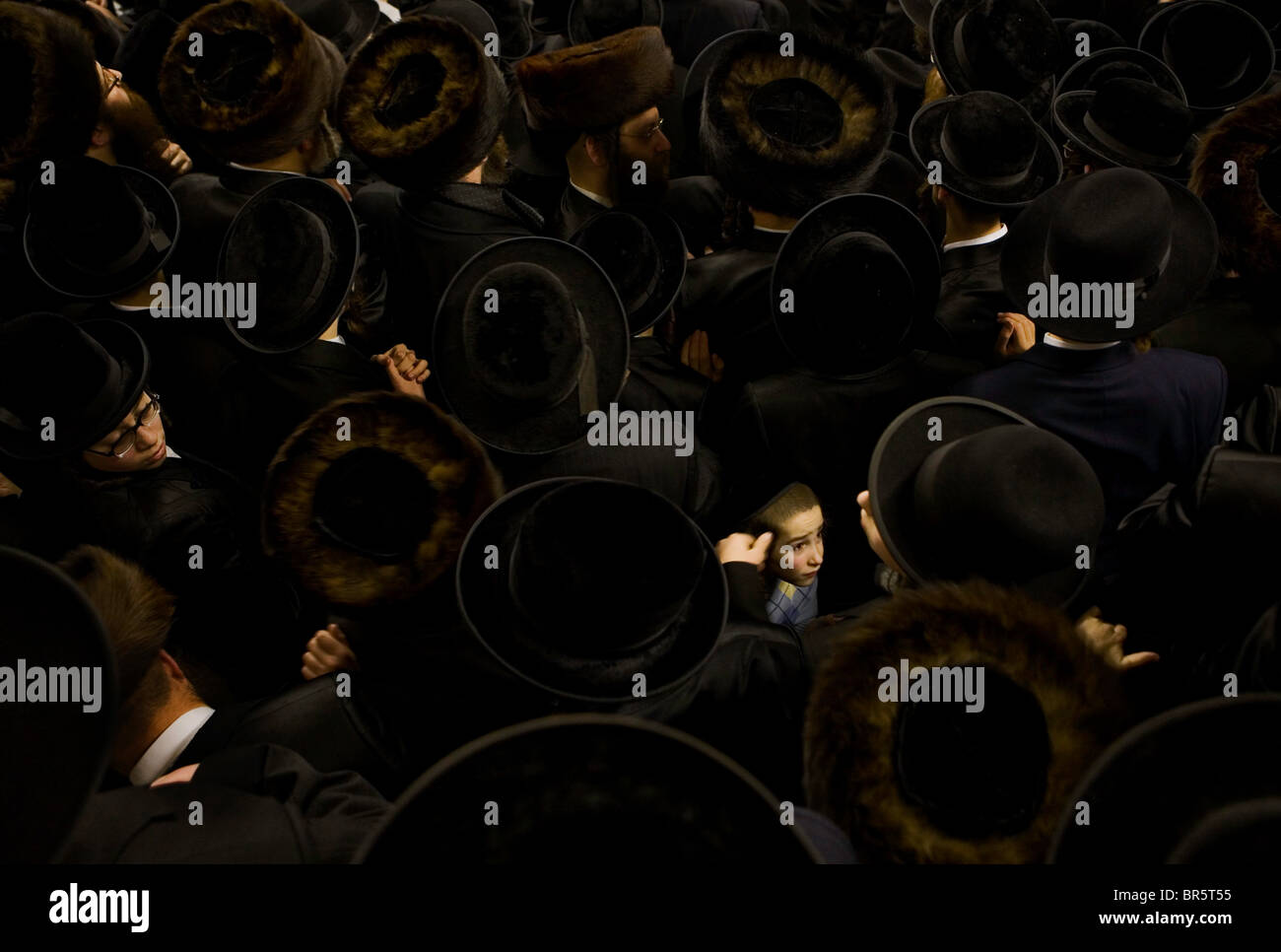 A young Orthodox Jewish boy surrounded by hundreds of Orthodox Jewish ...