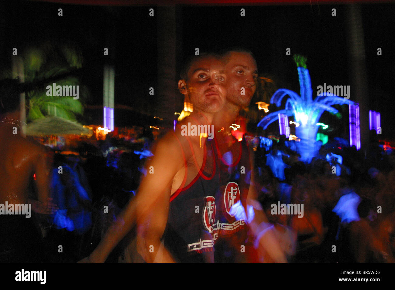 Two faces of a raver enjoying the music in the palm trees of a Full ...